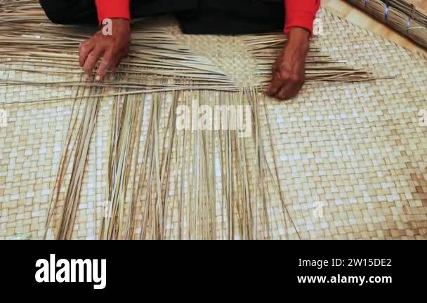 Close up shot of an expert old female hands weaving mat in Terengganu ...