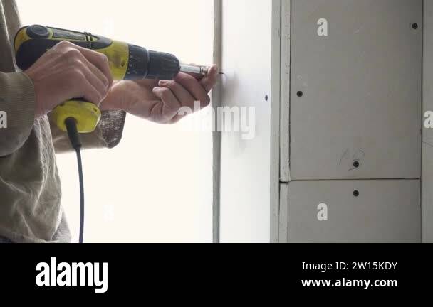 Tightens a screw with a screwdrive, tightening the bolts in drywall ...