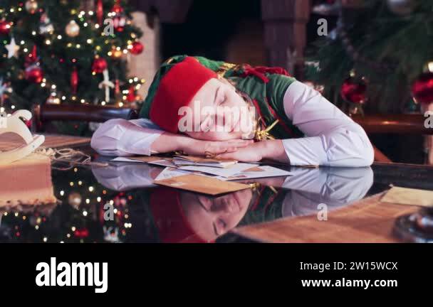 An elf girl wakes up and stretches in a room near a Christmas tree and ...