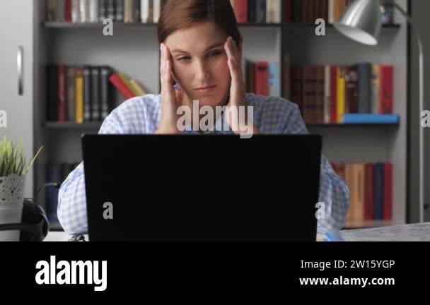 Headache. Woman works at computer in workplace, hands touches her forehead and temporal region ...