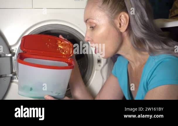 Young woman prepare to wash clothes in washing machine and takes out ...