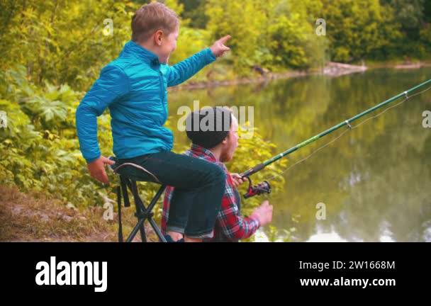 Two brothers on fishing - man holding the rod and his brother sitting ...