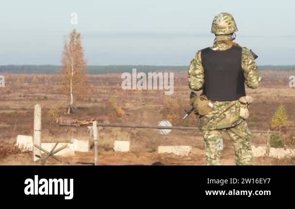 Close-up of an armed soldier. Armed soldiers patrol the territory. A ...
