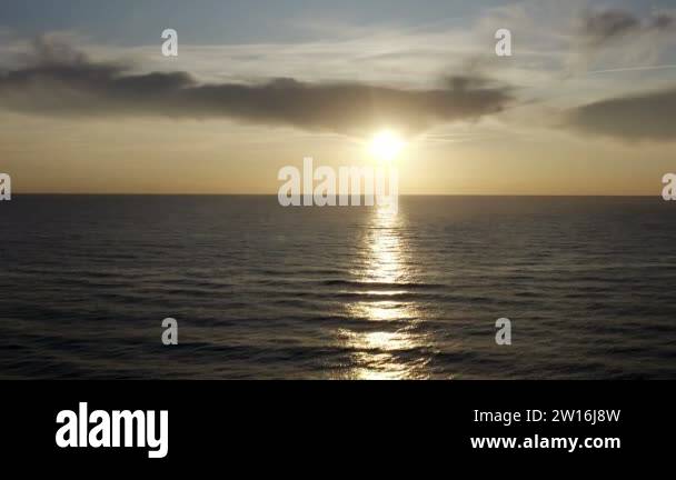 The sun sets far beyond the horizon, leaving a mark on the surface of ...
