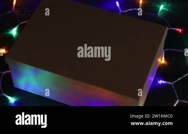 woman opening mystery box in the dark and revealing bright light coming ...