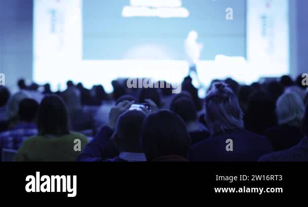 Speaker man on stage talking ans showing presentation on screen at ...