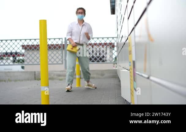 Woman client using automated self service post terminal machine or ...