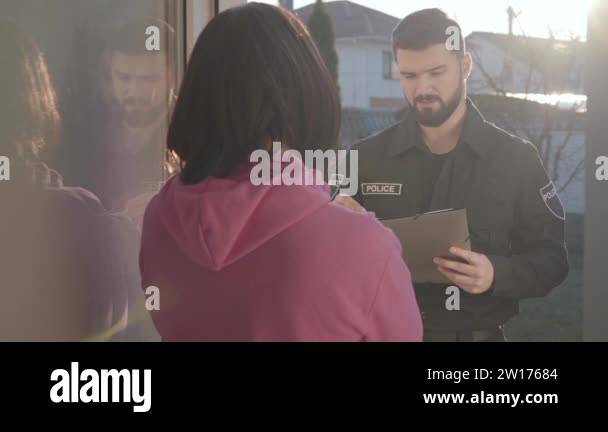 Back view of brunette Caucasian woman talking with police officer ...