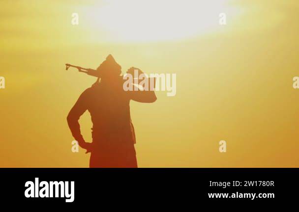Islamic warrior with Kalashnikov at sunset day. Muslim fighter is ...