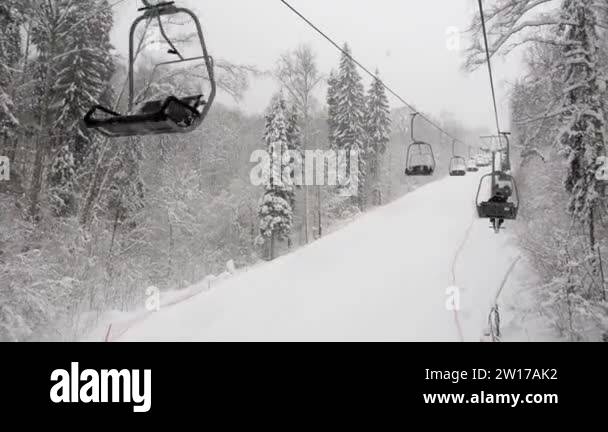 Aerial view of a two-seat cable car on a ski track in the winter snowy ...