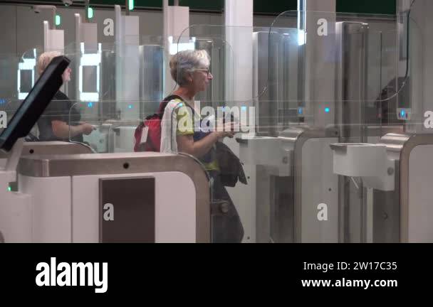 Air travelers pass through automated passport border control gates ...