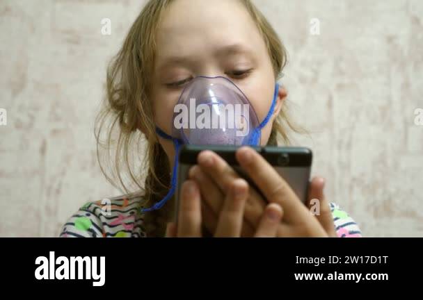 child with tablet is sick and breathes through an inhaler. close-up ...