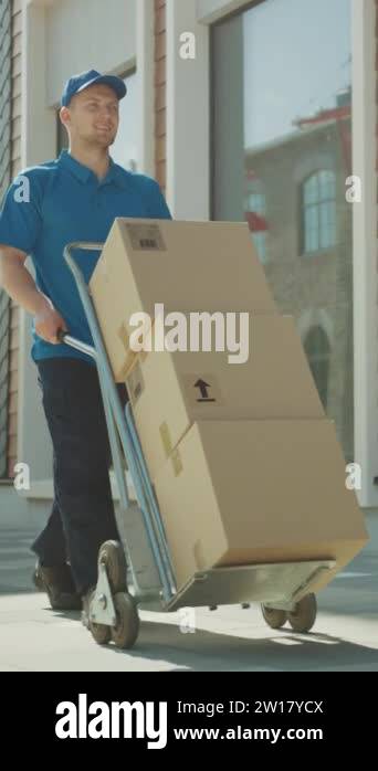Happy Young Delivery Man Pushes Hand Truck Trolley Full of Cardboard ...