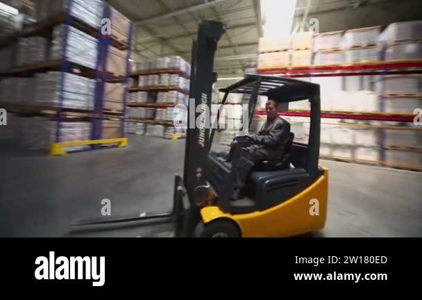 Man rides on loader in warehouse Stock Video Footage - Alamy