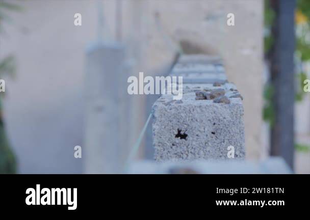Close shot at the bricklayers hands, male volunteer worker lays brick ...