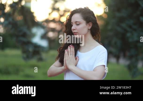 girl praying. girl folded her hands in prayer silhouette at sunset ...