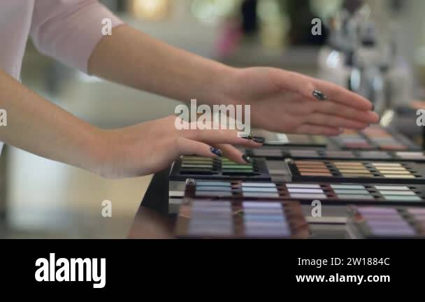 cosmetic shop, buyer woman select eyeshadow from palette of different ...