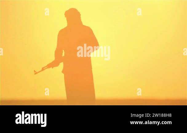 Islamic warrior with Kalashnikov at sunset day. Muslim fighter is ...