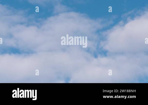 White clouds at the blue sky (horizontal moving). Fluffy white clouds ...