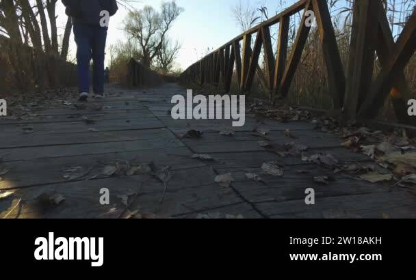 A man follows a girl through a nature walk, picks one path and walks ...