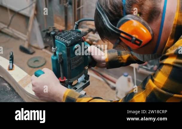 Carpentry industry - a man woodworker polishes the top of the wooden ...
