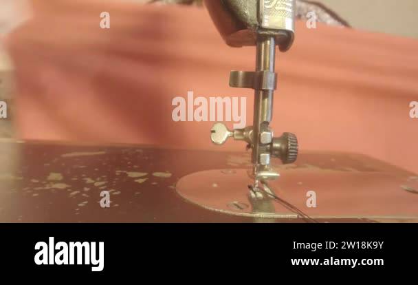 grandmother sews a red flag on an old sewing machine of the Soviet ...
