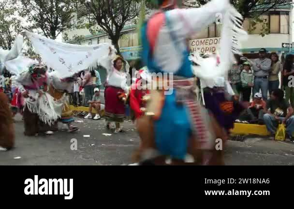 video of parade in city street, people dancing on road and wearing ...