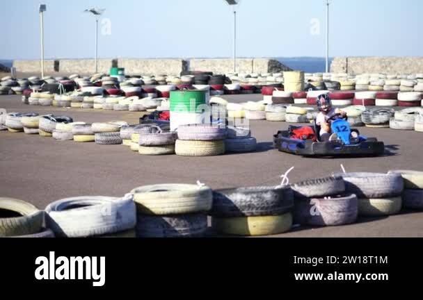 Young go cart race on circuit outdoors. There are safety barriers made ...