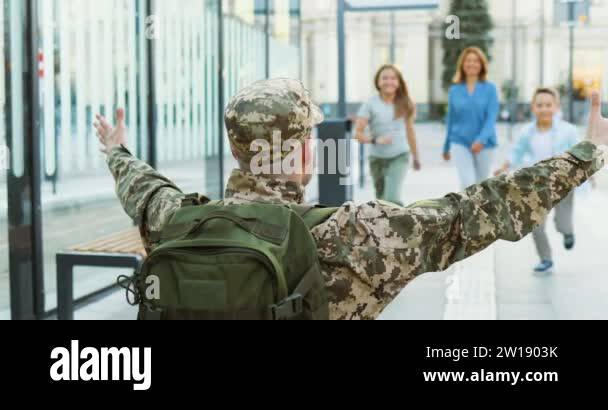 Rear of soldier in military uniform standing at train station with arms ...