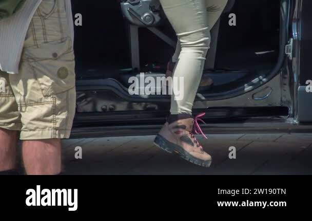 Two people are getting into the car and a driver is waiting to close ...