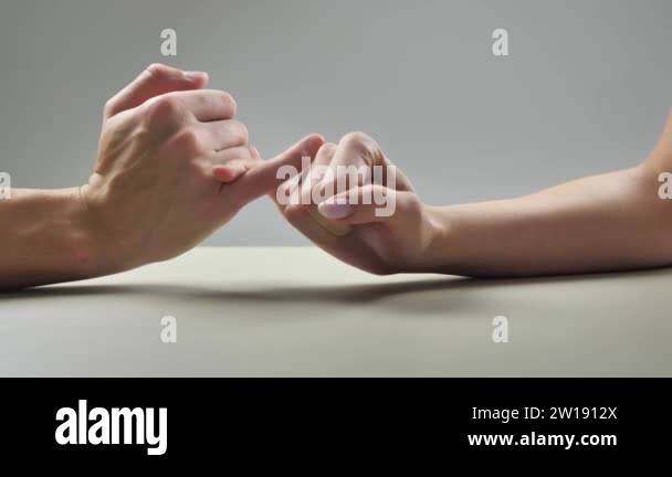 Close-up, adult couple hands of lovely couple hooking each others ...