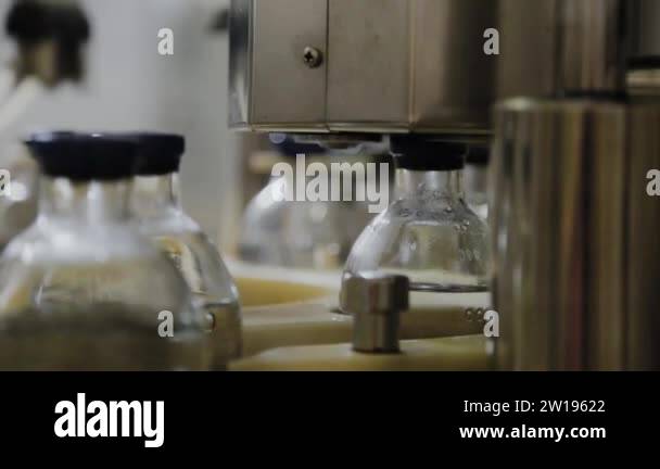 Pouring medicine on an assembly line into glass bottles for injection ...