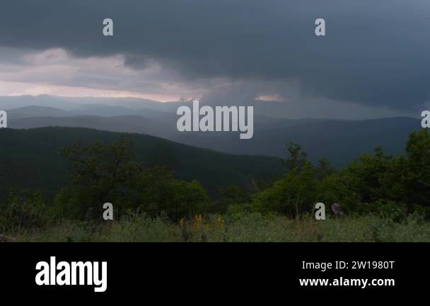 storm is coming - dramatic rain clouds approach the hill. Storm clouds ...