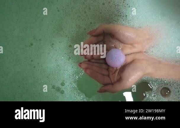 bomb bath salt dissolves in water and creates foam in womens hands ...