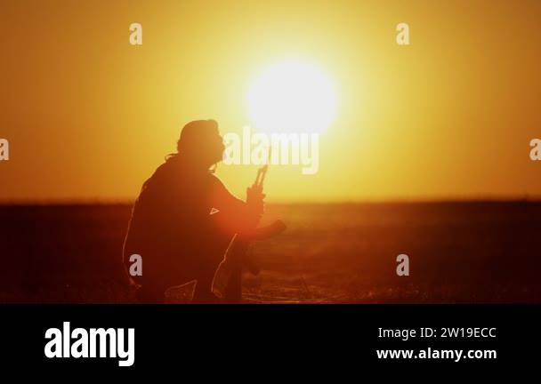 Islamic warrior with Kalashnikov at sunset day. Muslim fighter is ...