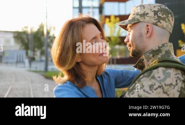 Happy young Caucasian couple talking and hugging at street with love ...