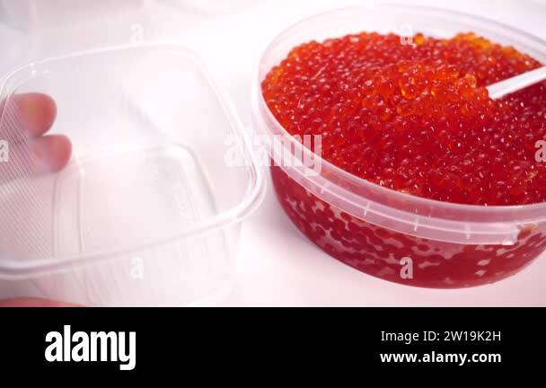 Red caviar type spoon. Plastic container with salted caviar of salmon ... Red caviar type spoon. Plastic container with salted caviar of salmon ...