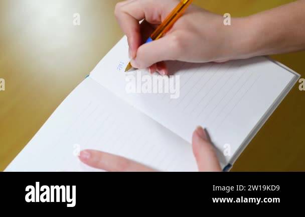 woman makes calculations by writing numbers in a notebook and summing ...