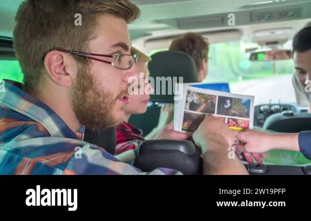 A group of friends is seating in a van and they are driving somewhere ...