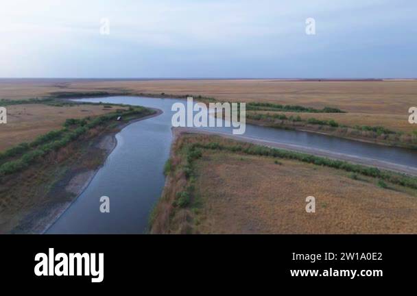 Aerial view of a tributary or bend of a river with green coastlines ...