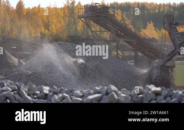 Gravel, rubble falling in a pile with conveyor belt.Industrial ...
