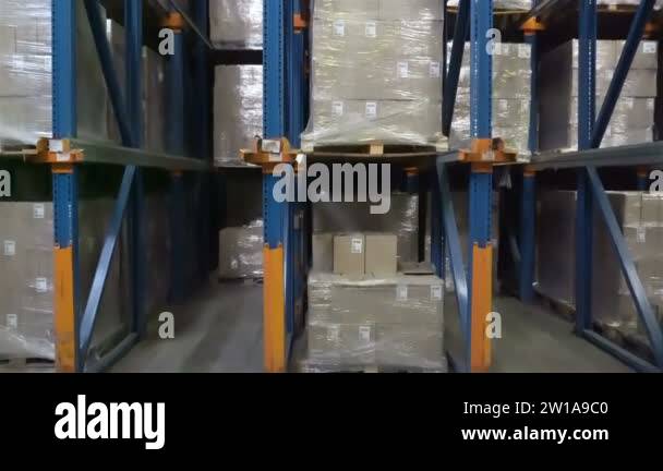 Work of loaders on loading pallets with cardboard boxes on racks in a ...