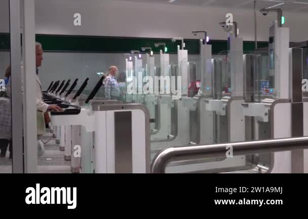 Air travelers pass through automated passport border control gates ...