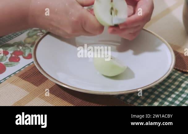 Adult woman cutting fresh apple with a knife and removing core from it ...