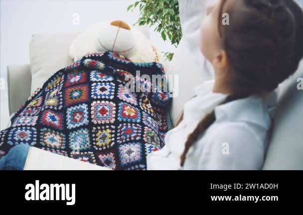 Cute little girl sitting with her legs curled up, reading fairy-tale ...