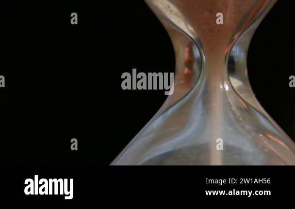 Hourglass counting the time in extreme close-up, black background Stock ...