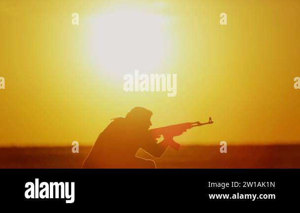 Islamic warrior with Kalashnikov at sunset day. Muslim fighter is ...