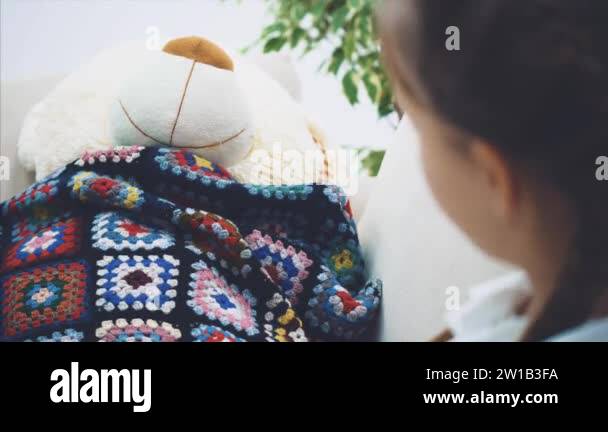 Cute little girl sitting with her legs curled up, reading fairy-tale ...