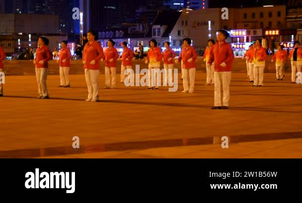 Old ladies outdoors wearing red uniforms, synchronized dance for new year, Chinese old people ...