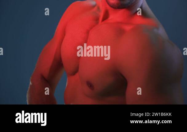 Shirtless ripped man posing with his arm down showing biceps and ...